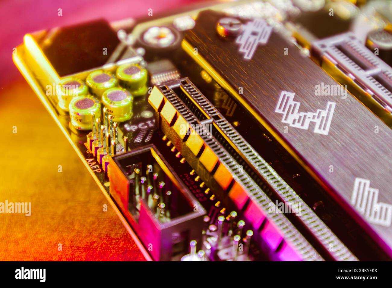 Motherboard with sockets and microchips close-up on desktop PC in colorful vivid light. Computer ...