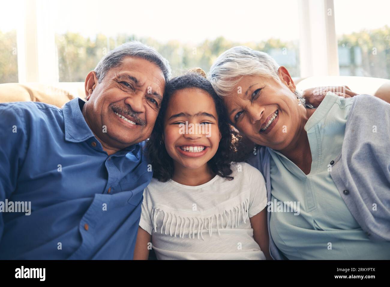 Grandparents, portrait and happy kid in home living room on sofa ...