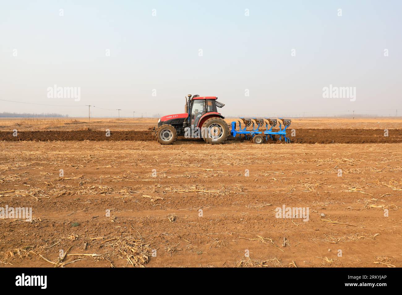 Farmers flatten their land with turning ploughs for spring ploughing ...