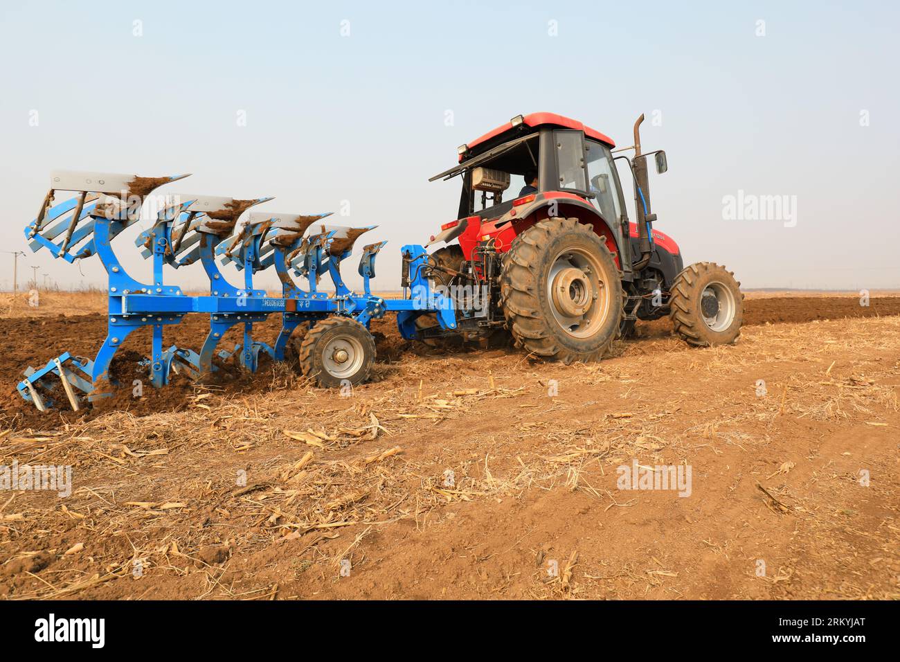 Farmers flatten their land with turning ploughs for spring ploughing ...