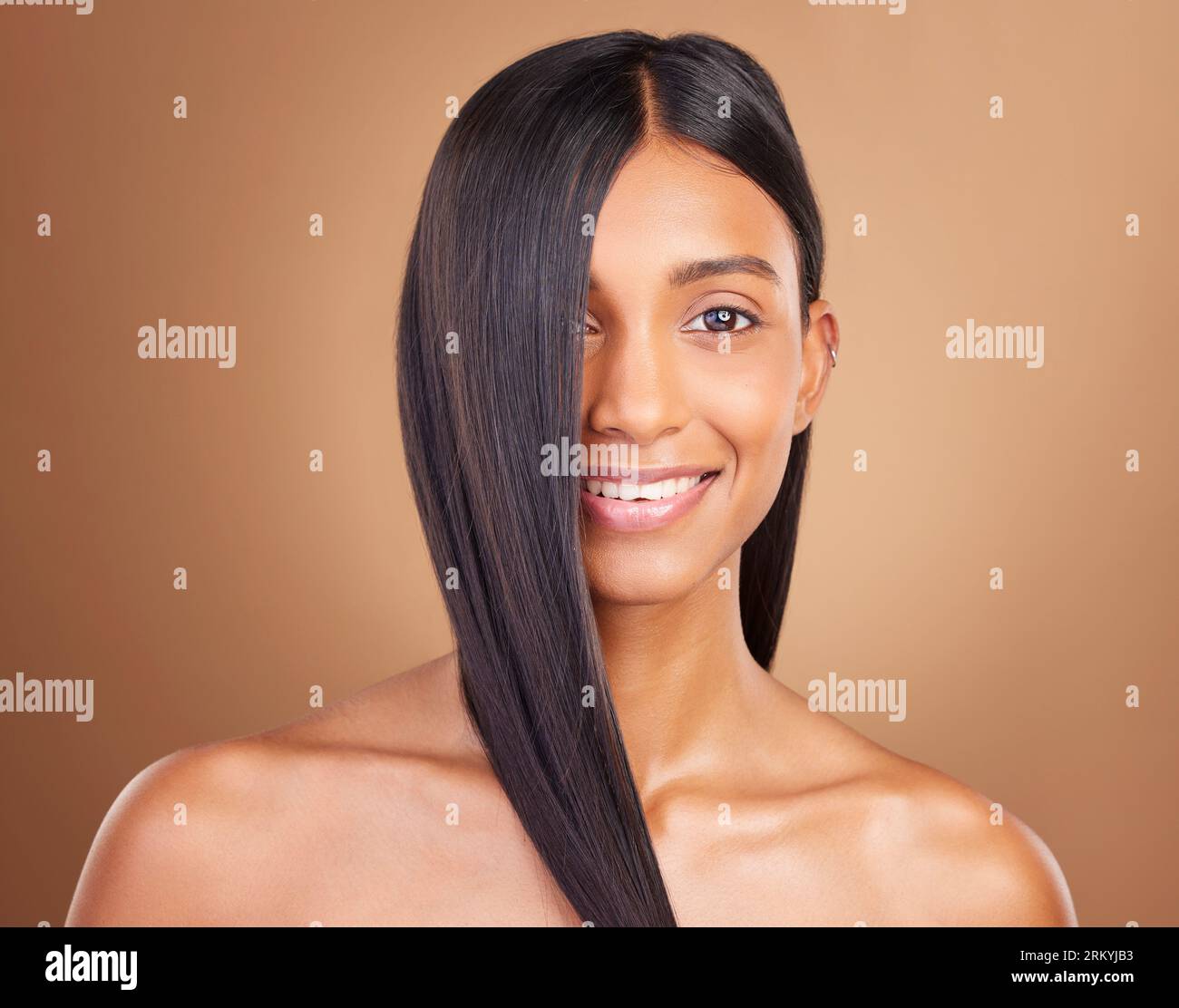 Portrait, hair care and woman with beauty, shine or dermatology on a brown studio background ...