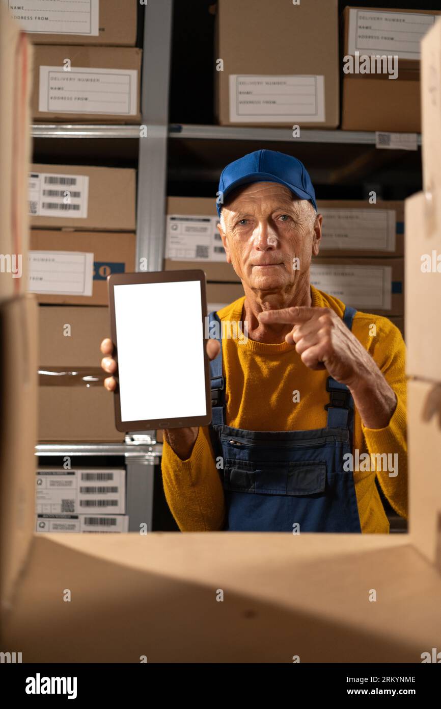 Old inventory warehouse manager holding digital tablet mockup blank ...