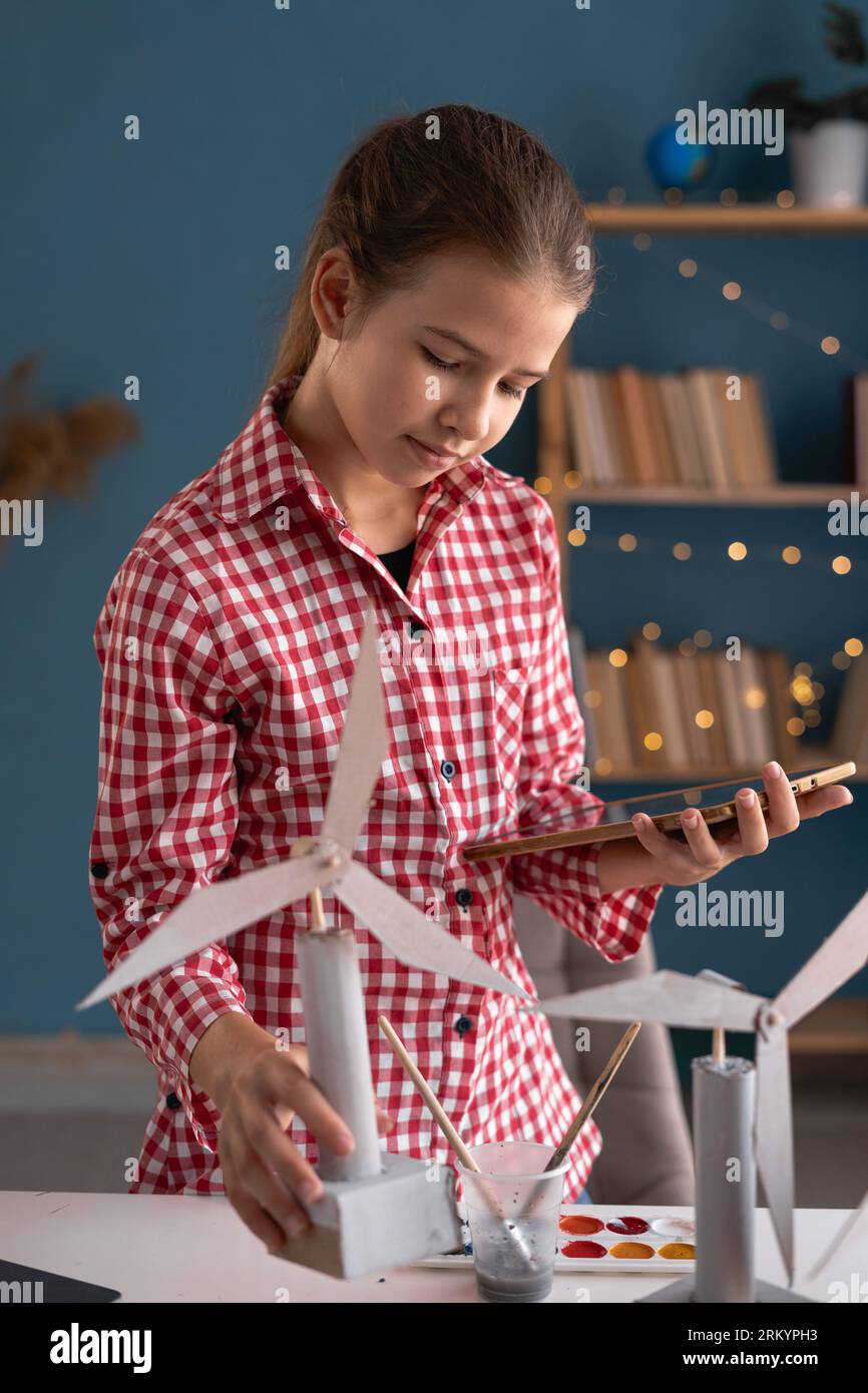 Cute girl with tablet computer, toy house model and wind turbine at ...