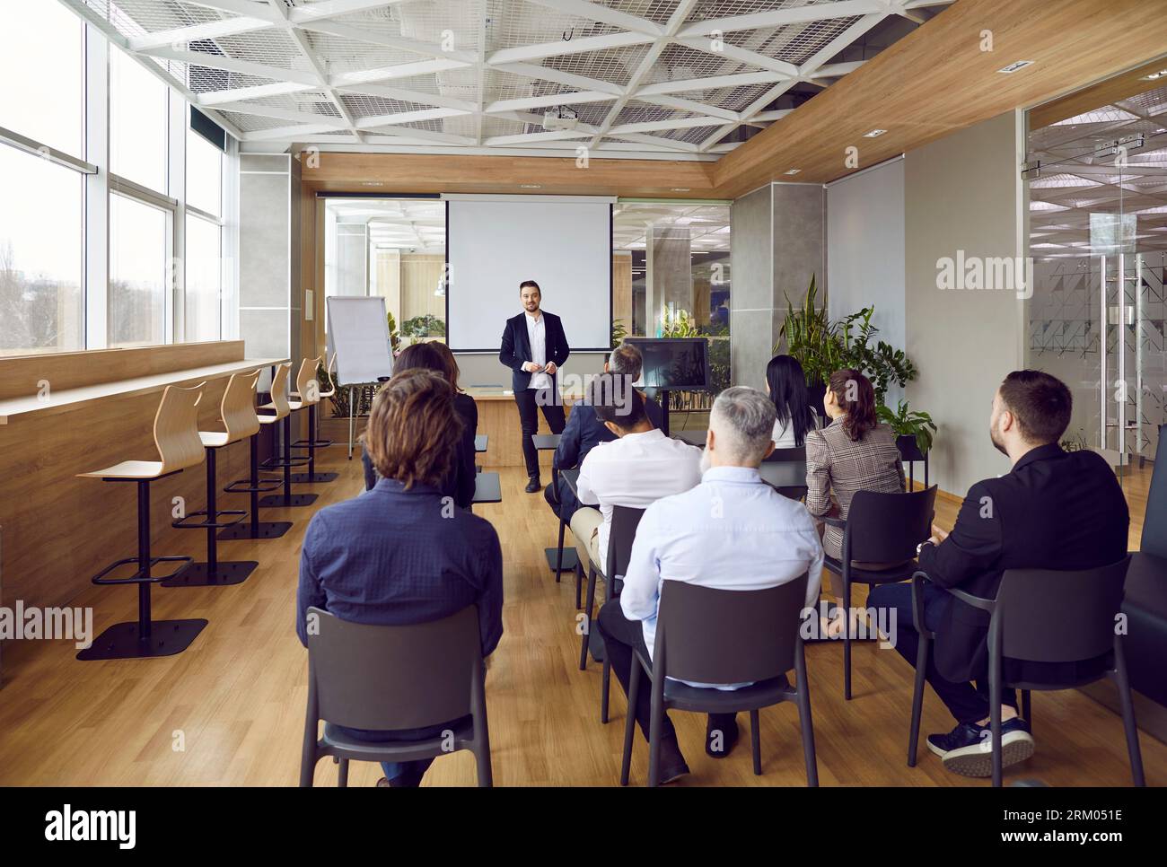 Business coach giving a lecture to a group of people in a classroom or ...