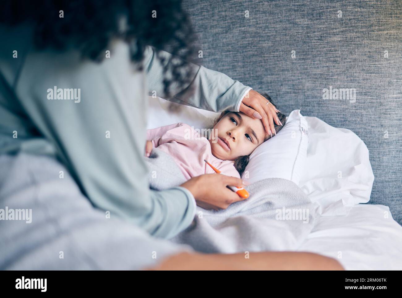Mother, thermometer and sick child in bedroom with illness, virus or ...