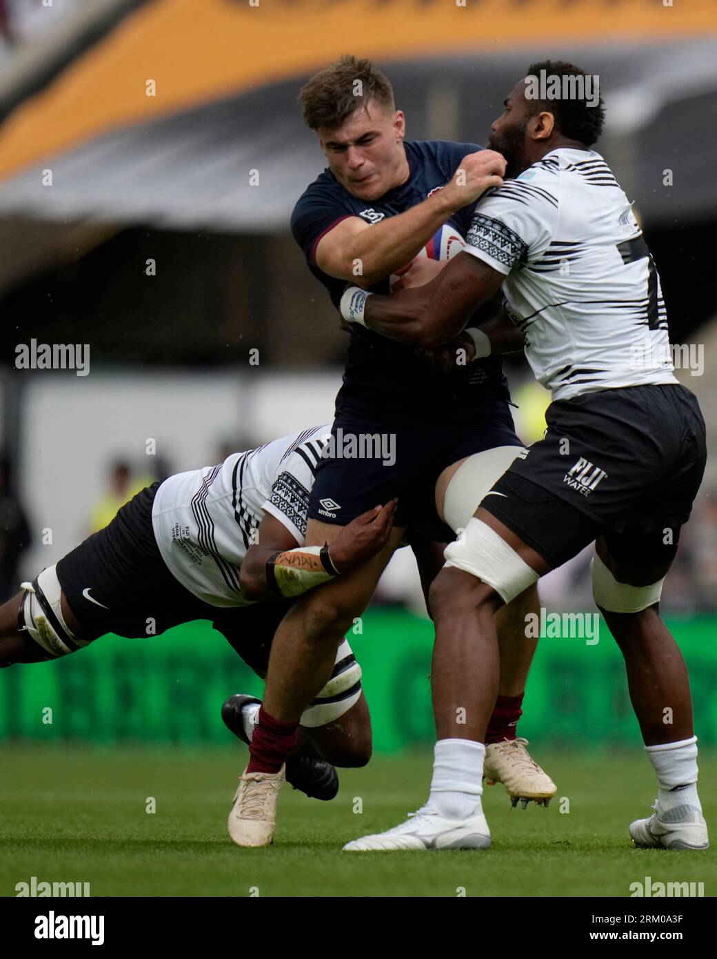 England's Theo Dan, centre, is tackled by Fiji's Lekima Tagitagivalu ...