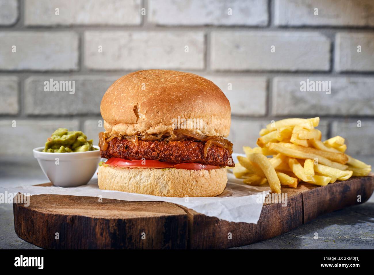 Close up delicious fresh burger and fries on wooden board. and stone ...