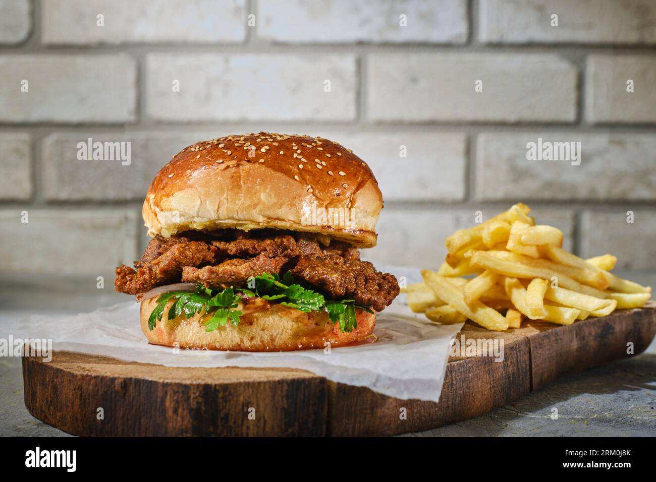 Close up delicious fresh burger and fries on wooden board. and stone ...