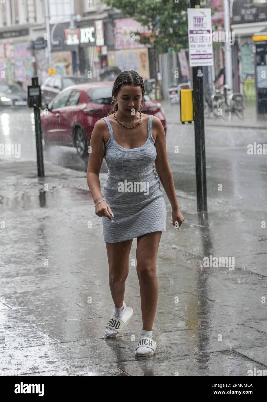 A woman gets caught in a heavy rain shower in Ladbroke Grove, west ...