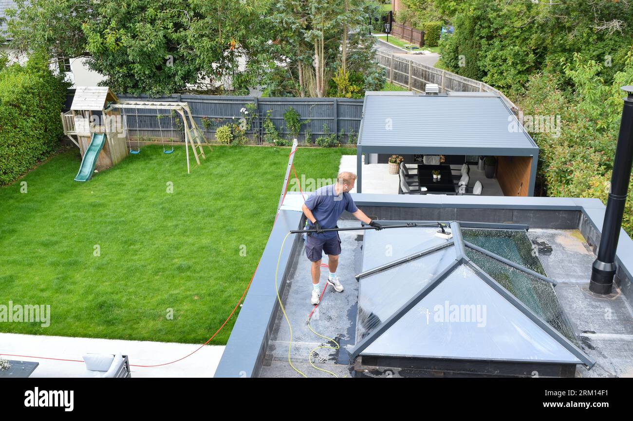 Man is cleaning the roof top windows on a nice day Stock Photo - Alamy