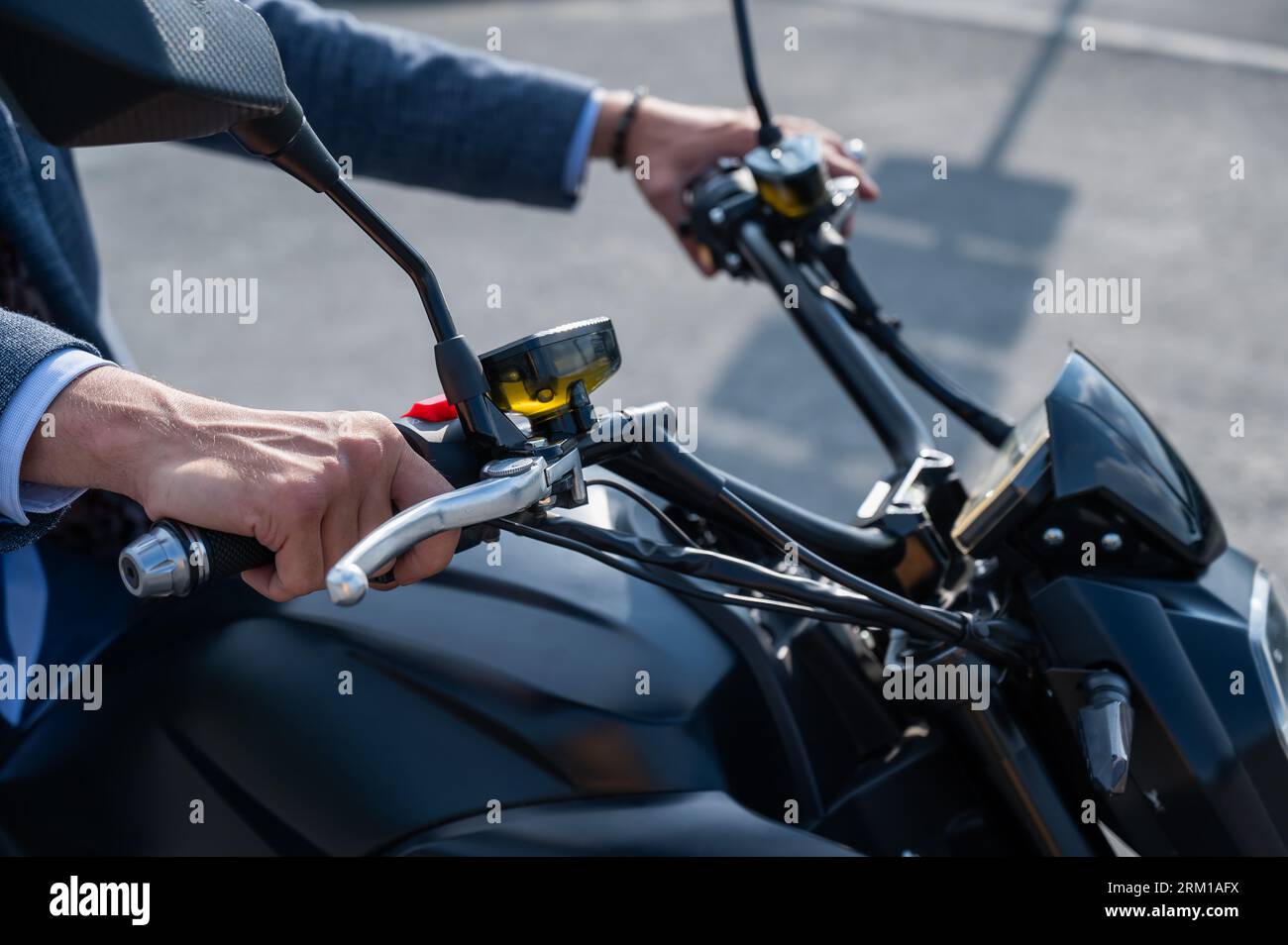 Caucasian man rides an electric motorcycle. Close-up of male hands on ...