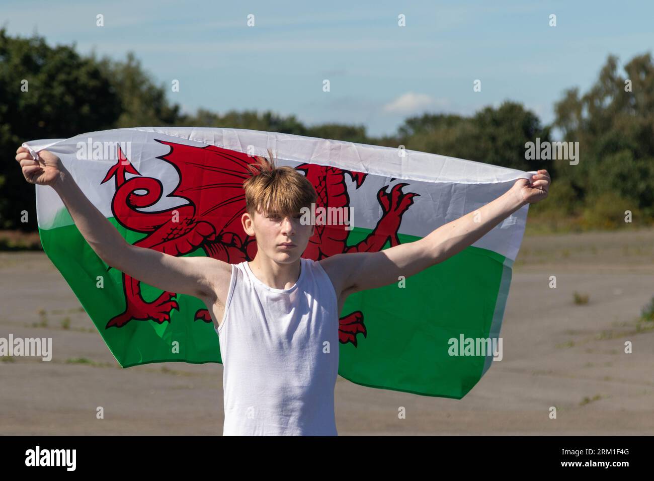 A happy and laughing teenage boy waving the Welsh Flag Stock Photo - Alamy