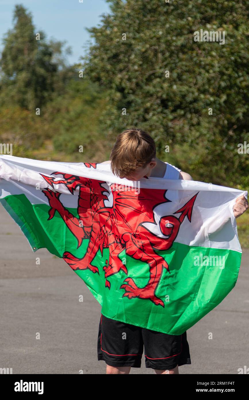 A happy and laughing teenage boy waving the Welsh Flag Stock Photo - Alamy
