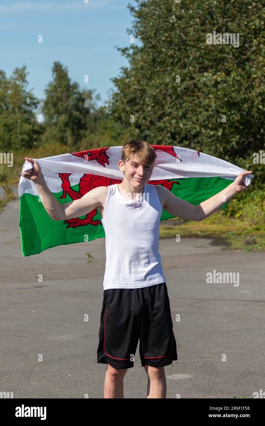 A happy and laughing teenage boy waving the Welsh Flag Stock Photo - Alamy
