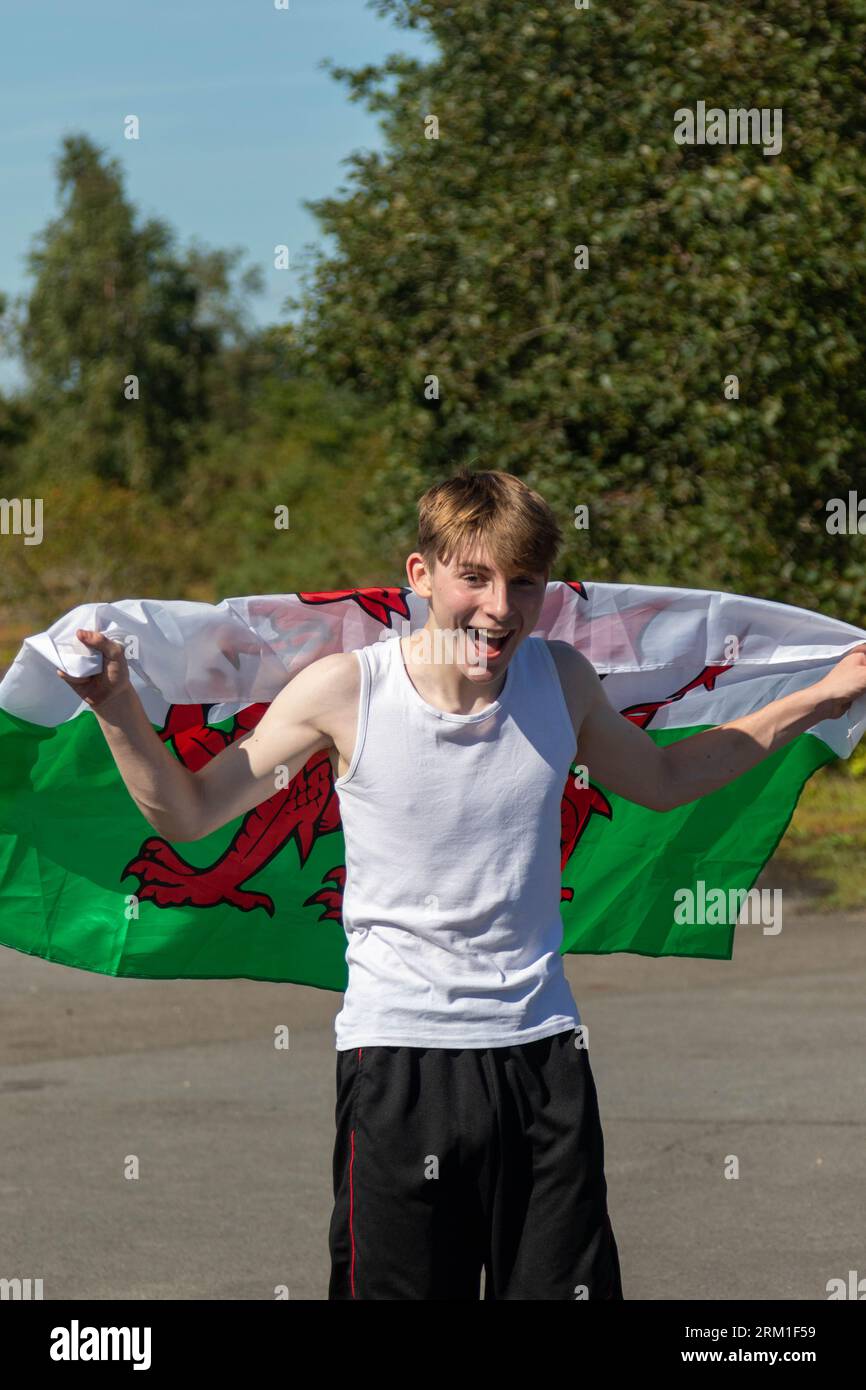 A happy and laughing teenage boy waving the Welsh Flag Stock Photo - Alamy
