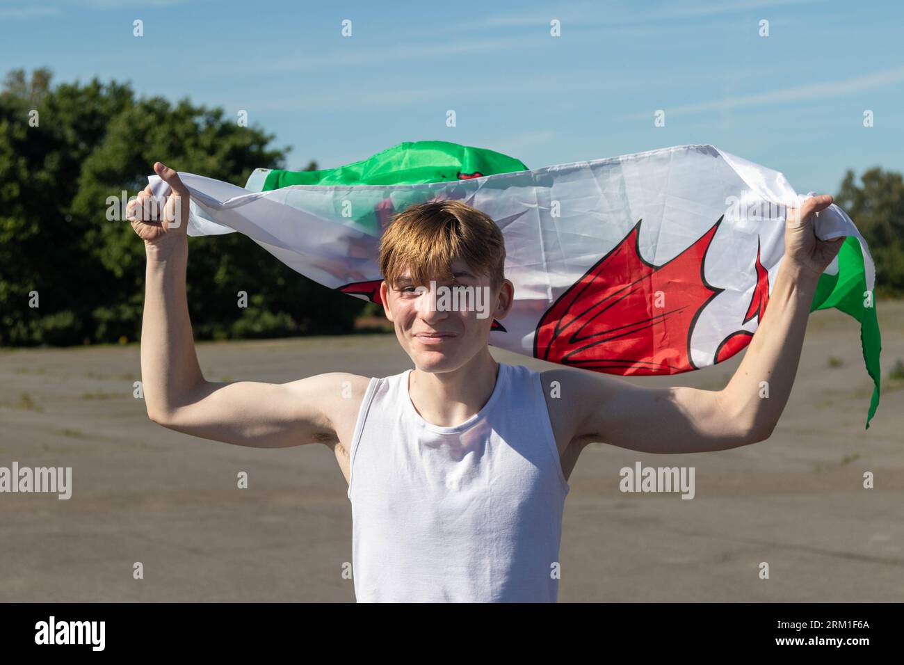 A happy and laughing teenage boy waving the Welsh Flag Stock Photo - Alamy