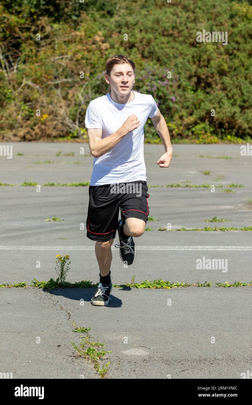 Fit and sporty teenage boy running during a warm summer’s afternoon ...