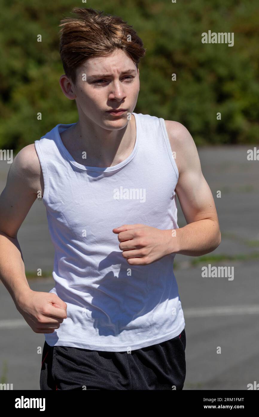 Fit and sporty teenage boy running during a warm summer’s afternoon ...
