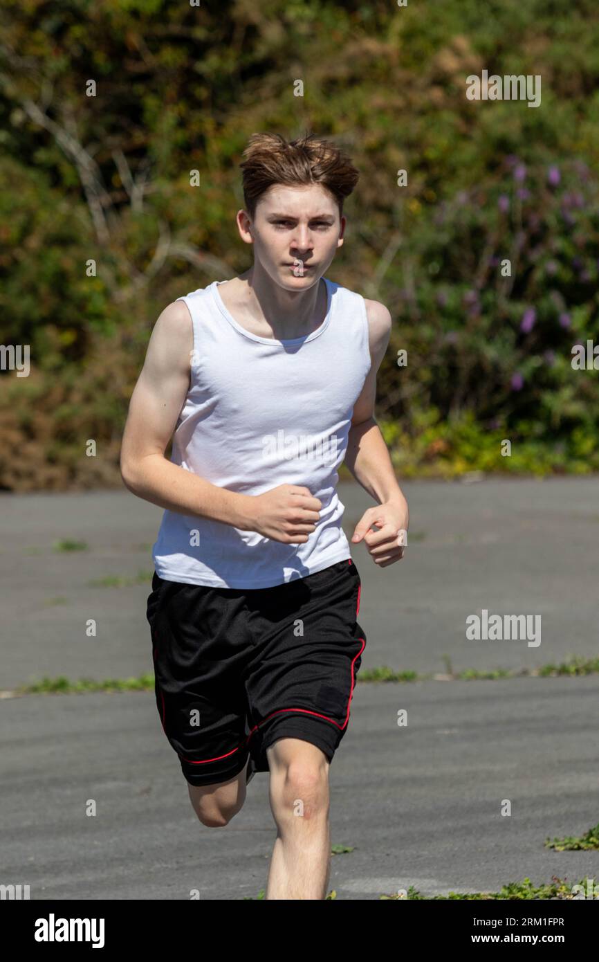 Fit and sporty teenage boy running during a warm summer’s afternoon ...