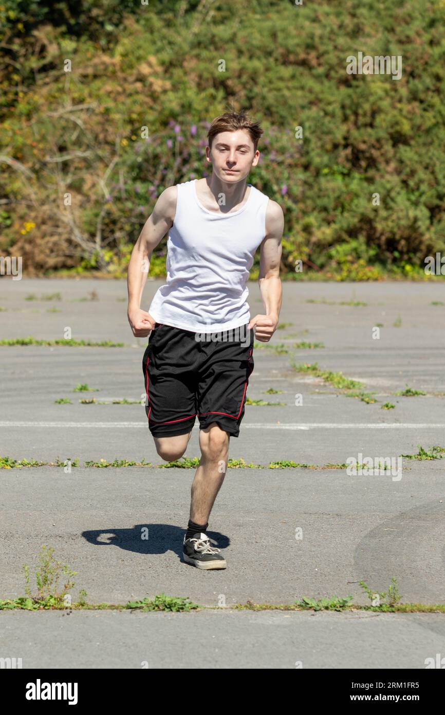 Fit and sporty teenage boy running during a warm summer’s afternoon ...