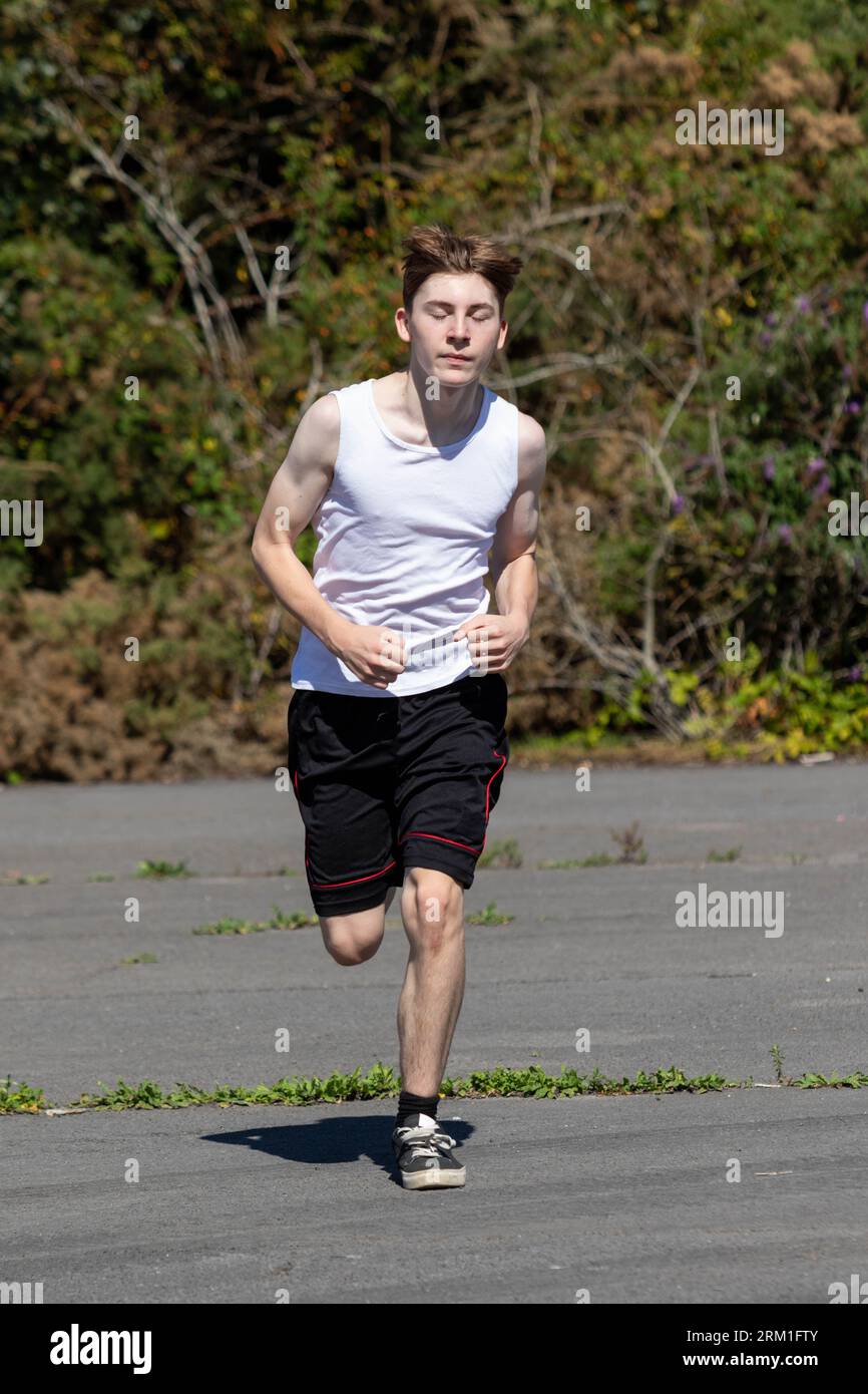 Fit and sporty teenage boy running during a warm summer’s afternoon ...