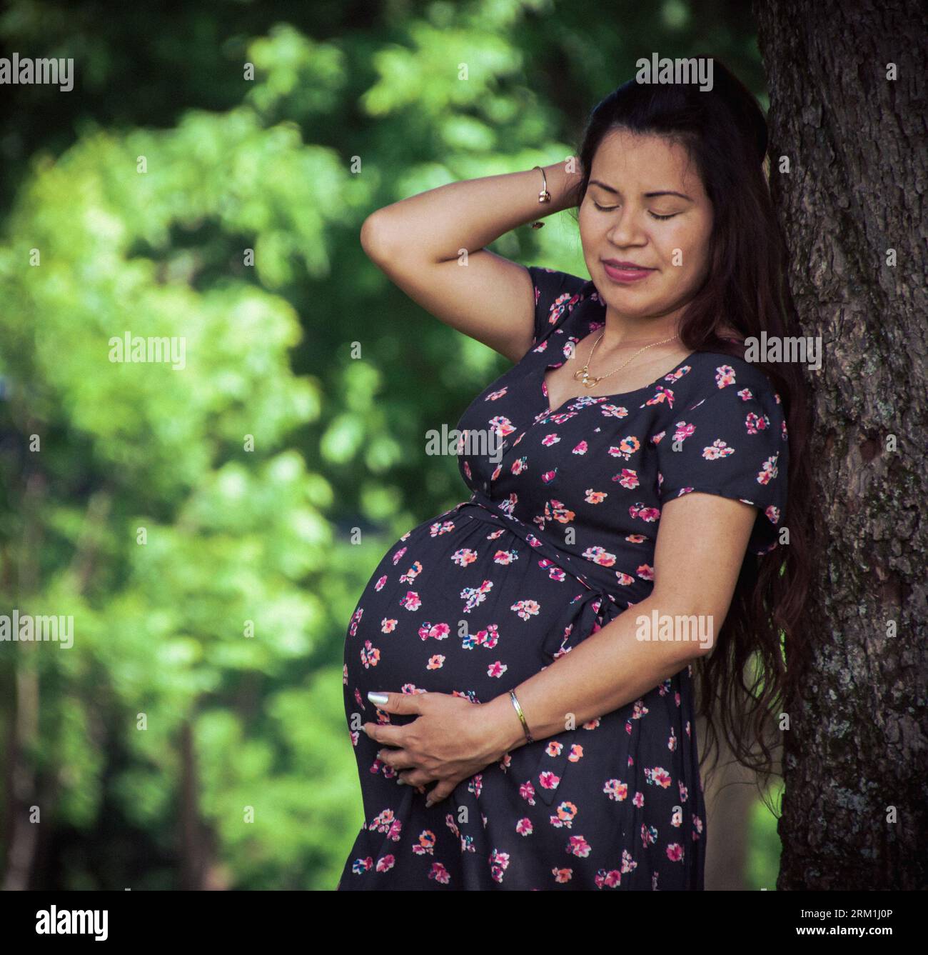 Mexican mother outside posing with her belly showing, expecting Stock ...