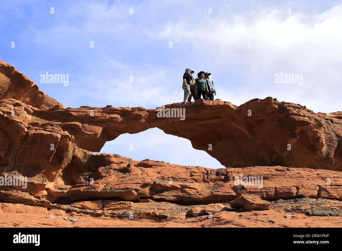 Tourists at the Little Rock bridge (Raqabat al Wadak), Wadi Rum, Unesco ...