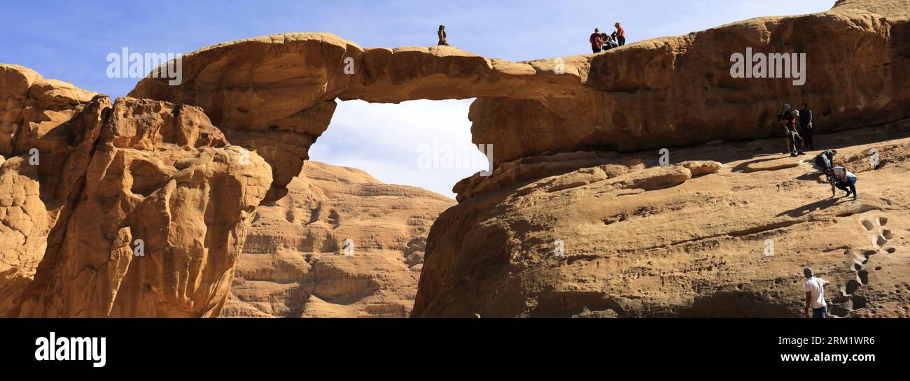 Tourists at the Burdah rock bridge, Wadi Rum, Unesco World Heritage ...