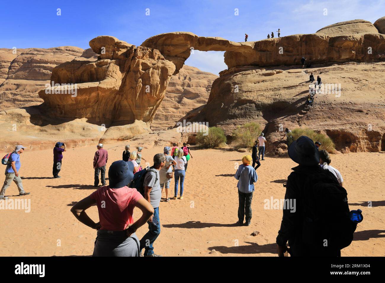Tourists at the Burdah rock bridge, Wadi Rum, Unesco World Heritage ...