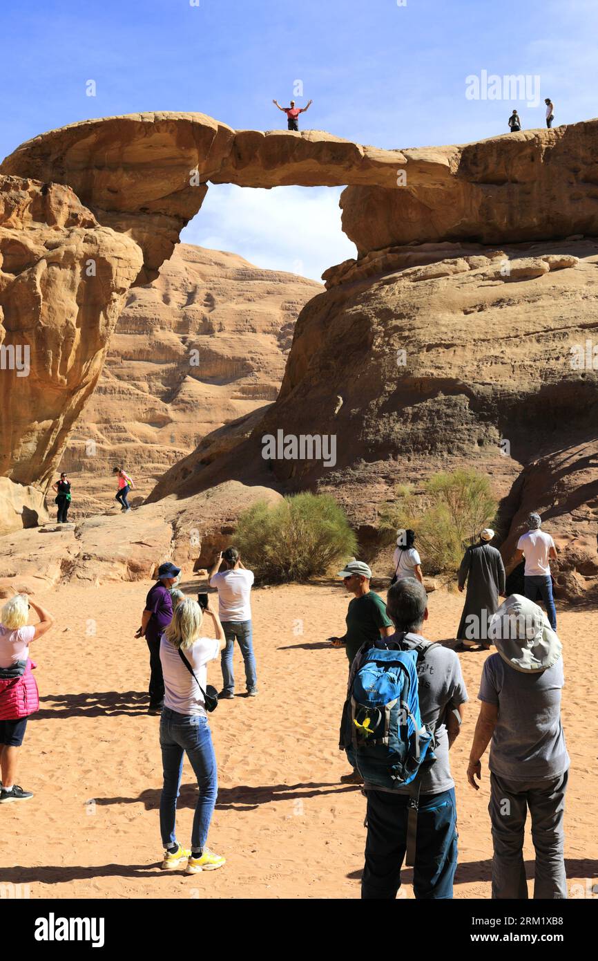 Tourists at the Burdah rock bridge, Wadi Rum, Unesco World Heritage ...