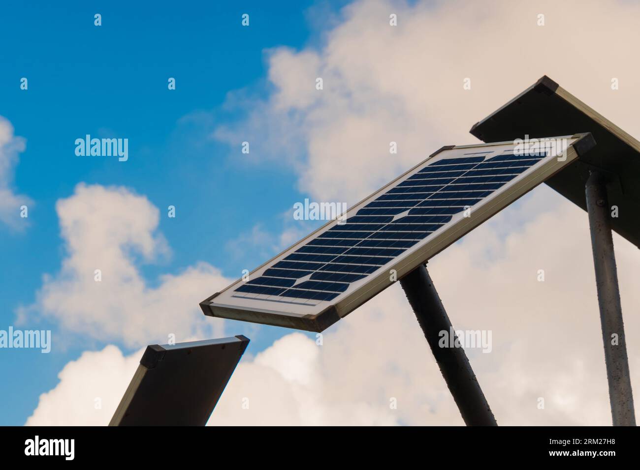 View of solar panels against white clouds in the blue sky - close up ...