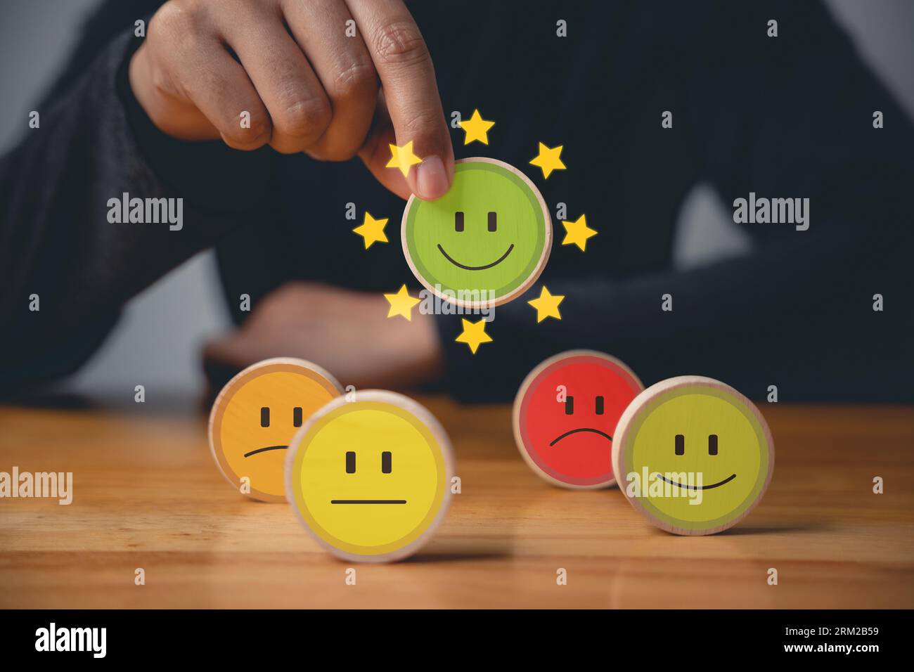 Selecting a smiley face on a wooden block circle Stock Photo - Alamy