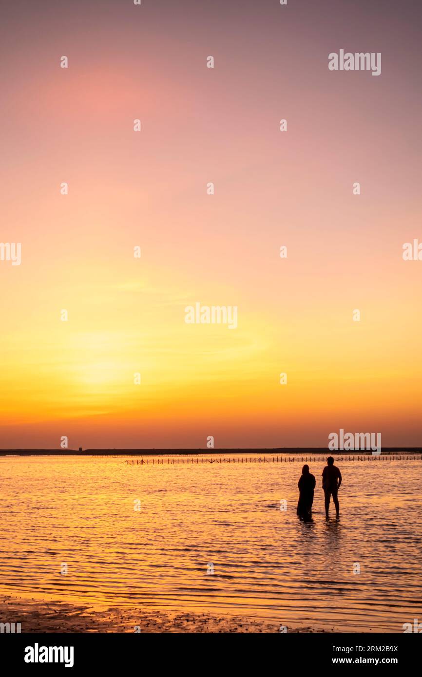 A couple, man and woman walking in shallow water, Bahrain Al-Seef ...