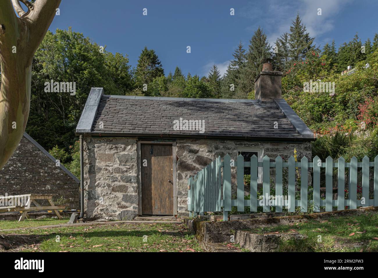 Small cottage stone built cottage with a blue picket fence Stock Photo ...