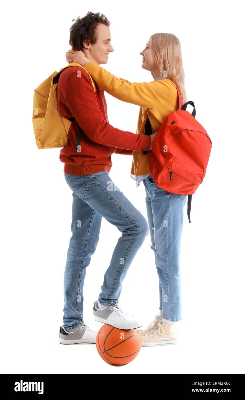 Teenage couple with ball hugging on white background Stock Photo - Alamy