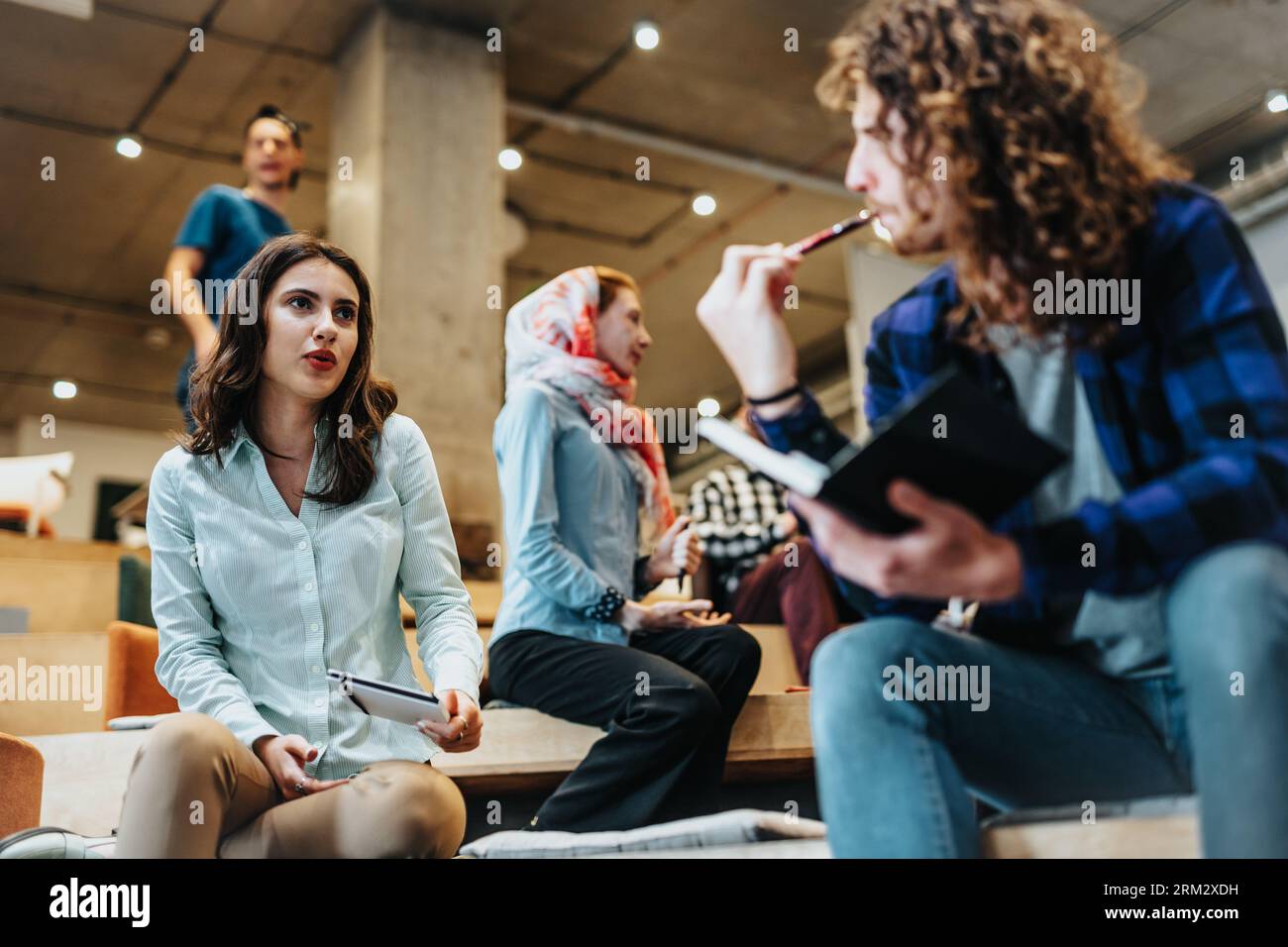 Two young business amateurs talking and brainstorming at the office ...