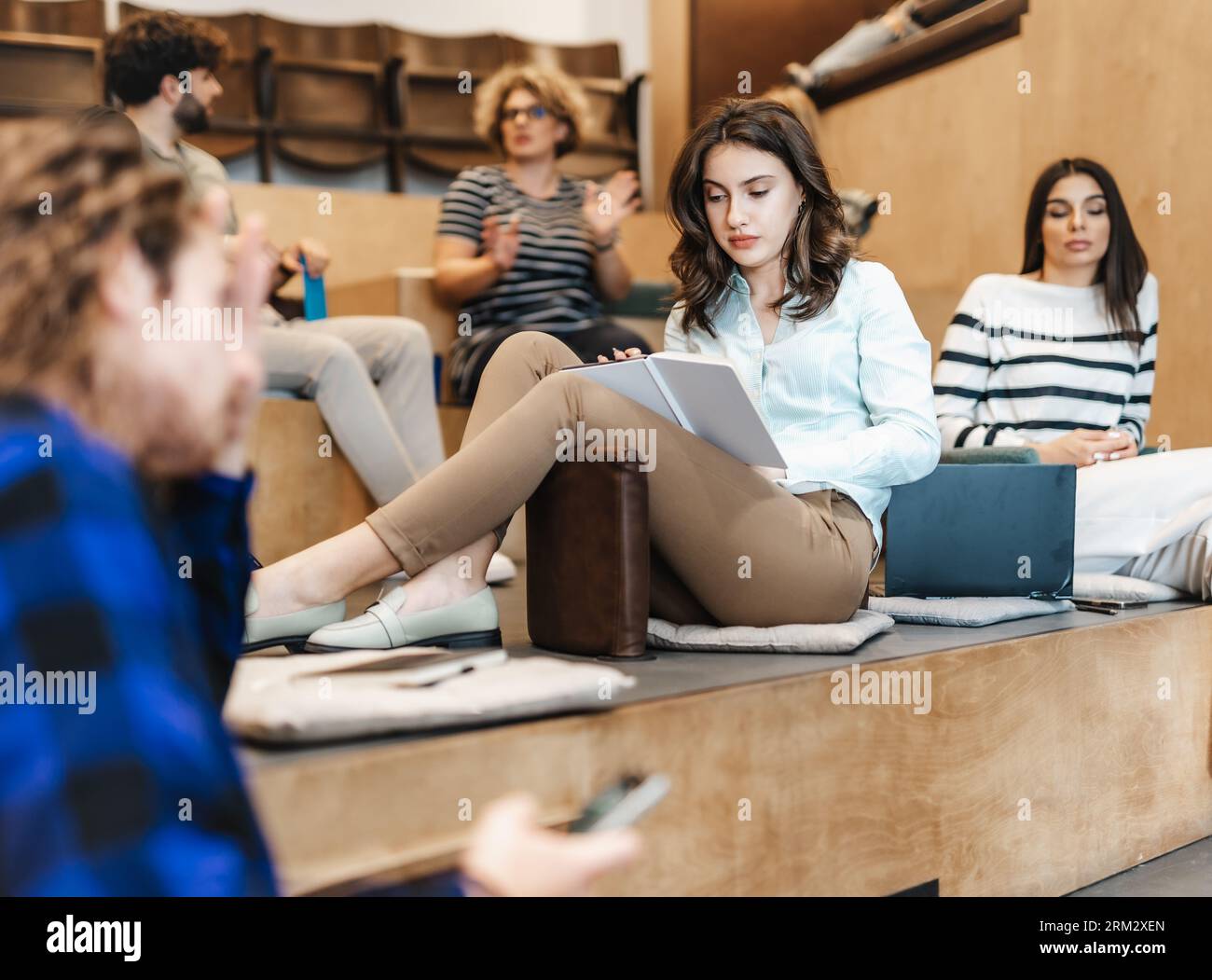 Junior, tired, male and female employees sitting at comfy workplace ...