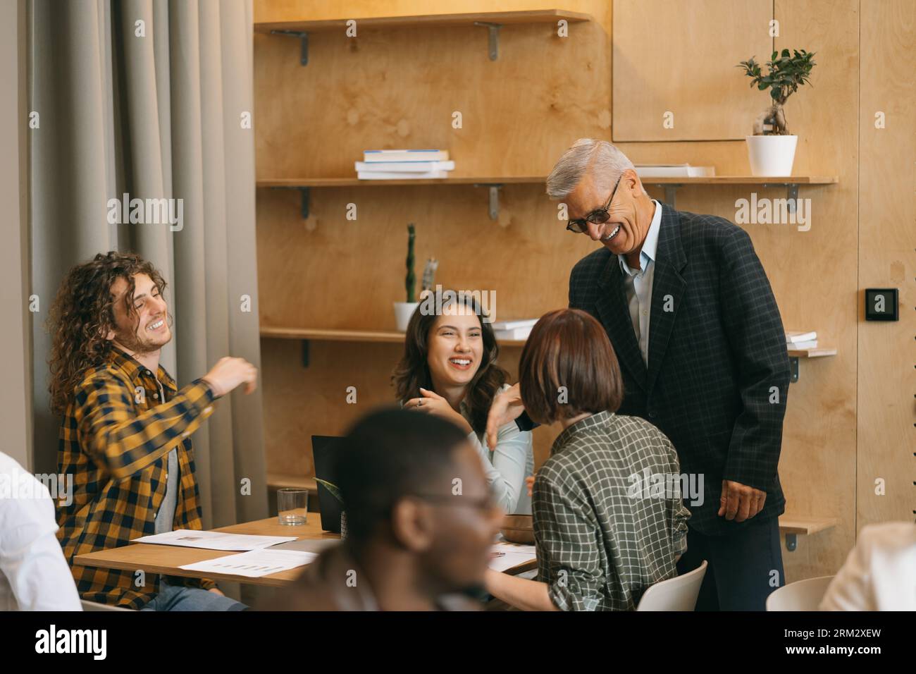 Mature business boss greeting his junior employees Stock Photo - Alamy