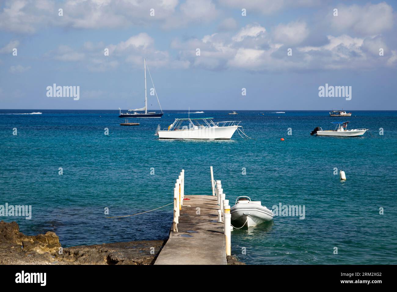 The view of a little pier and different type of boats near Grand Cayman ...