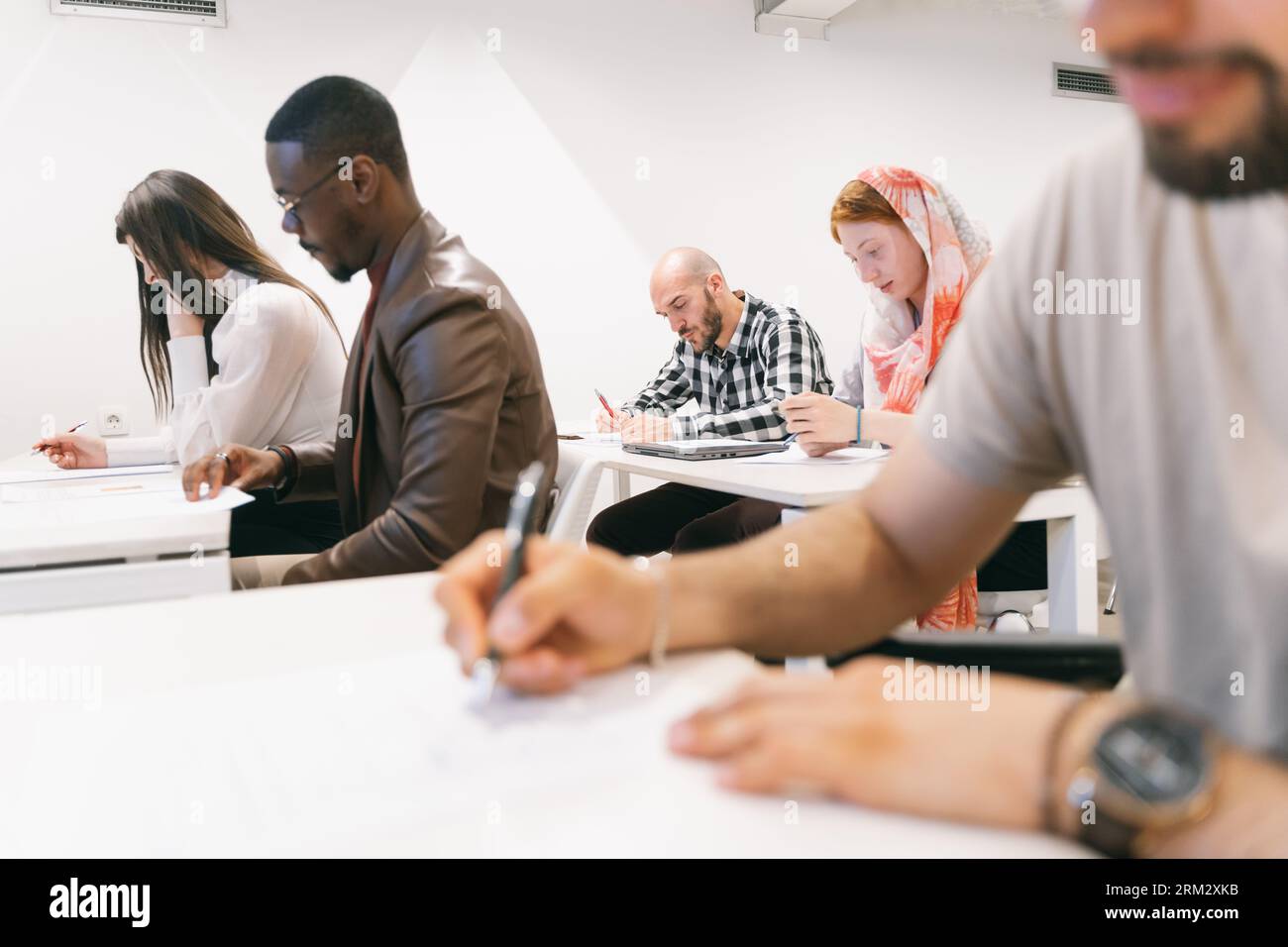 Multicultural students solving an exam Stock Photo - Alamy