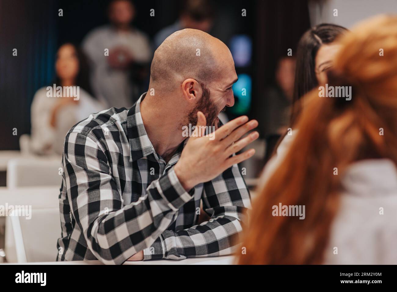 Bald male employee having fun conversation and laughing during ...