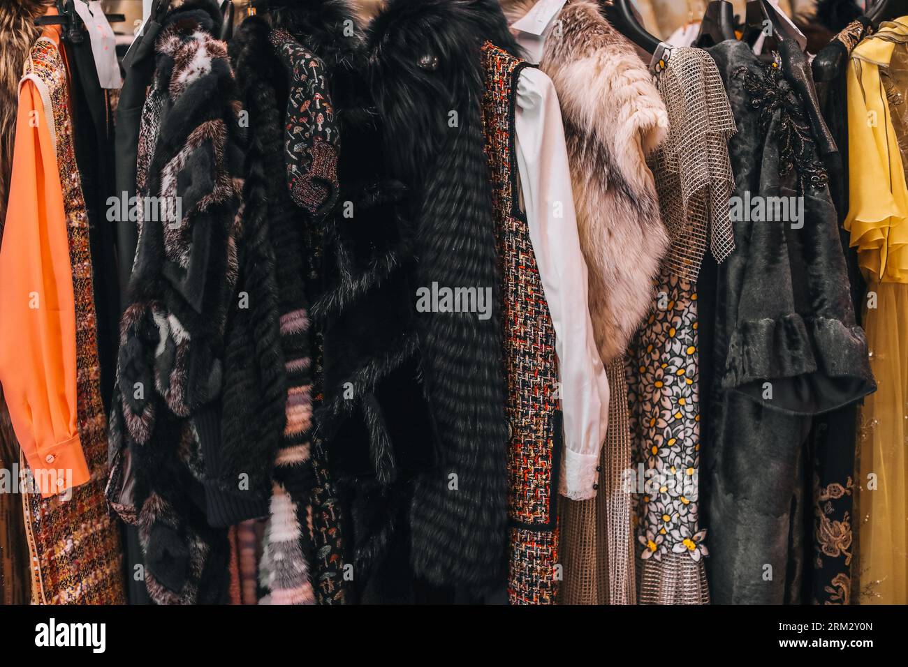 Women's cloth and fur coats hanging in a row on the fashion backstage ...