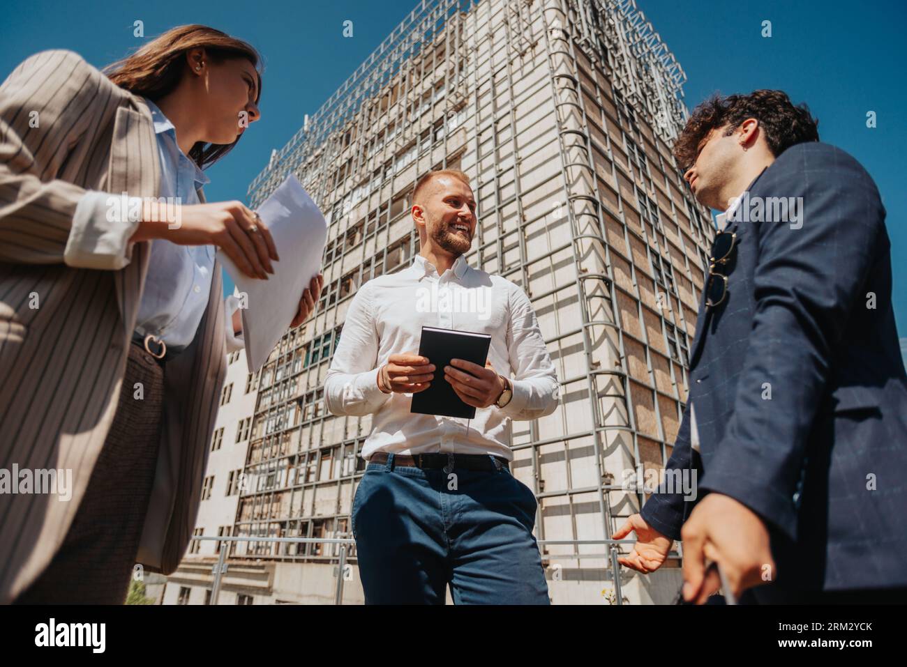 Young engineers discussing. Construction engineers talking and standing ...