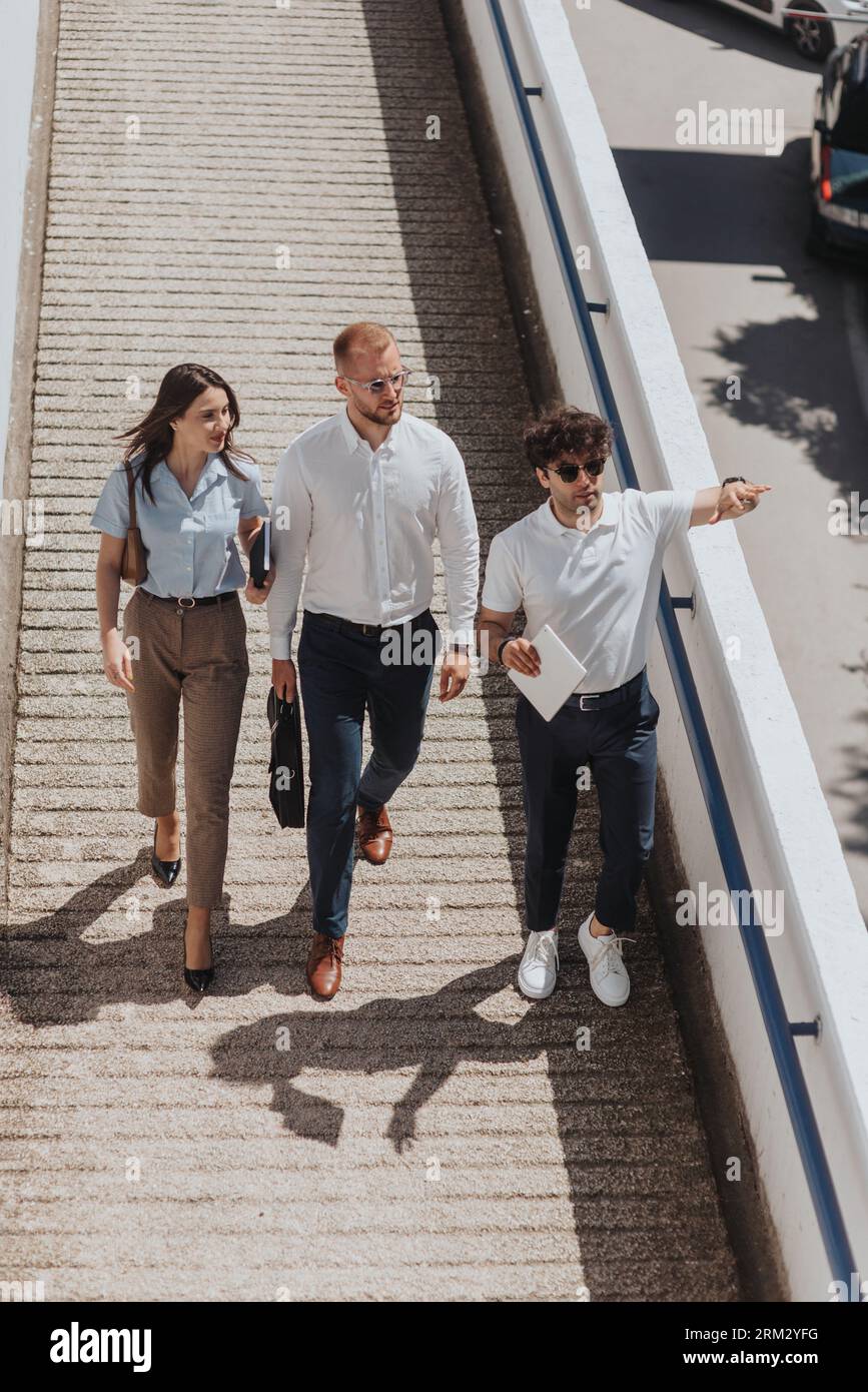Business partners walking on modern walkway and discussing work. Above ...