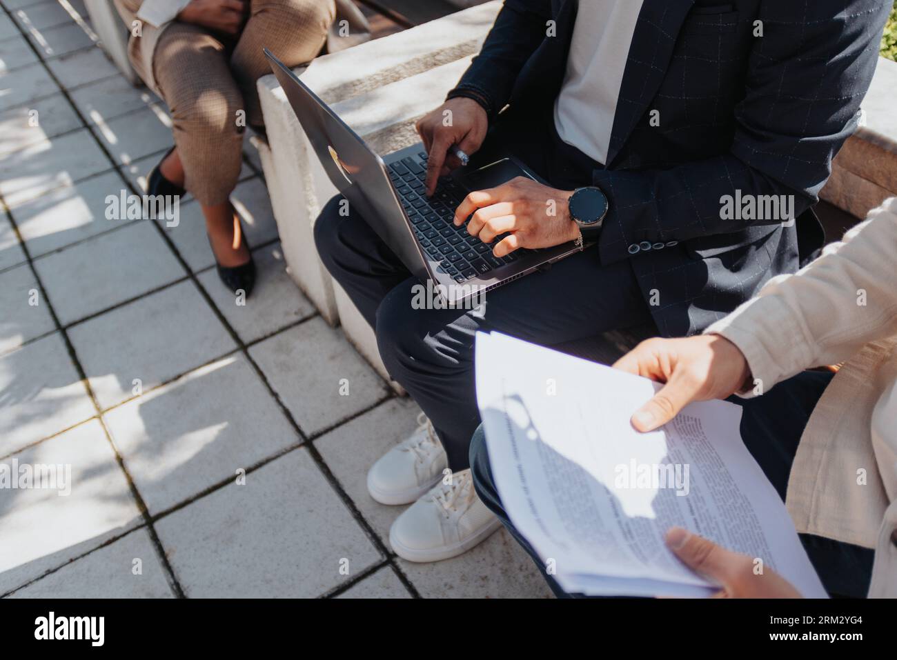 Business person writing statistics on the lap top, his male partner ...
