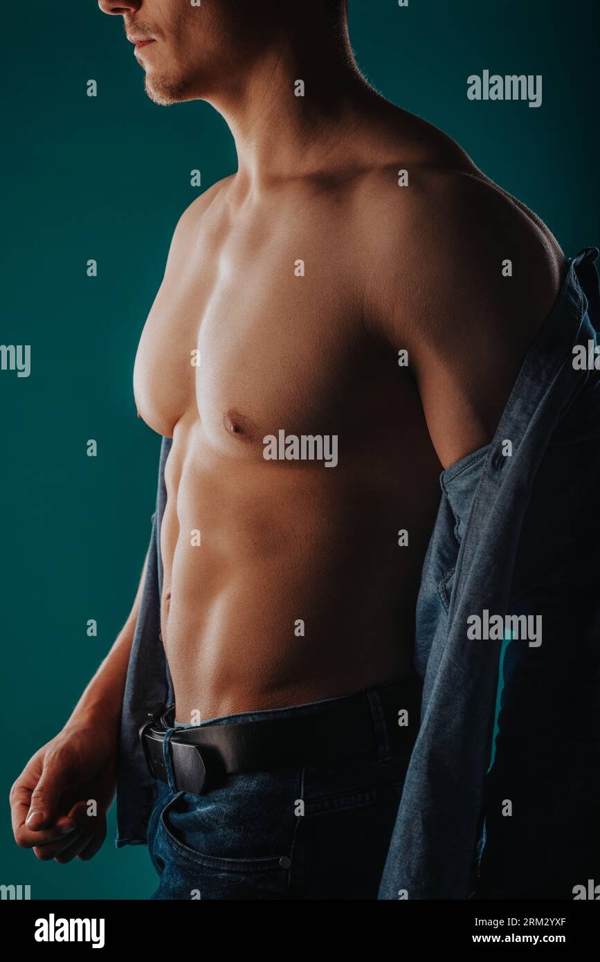 Stunning and muscular man standing in a green room and flexing his ...