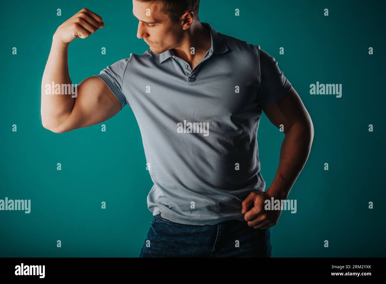 Muscular and attractive man standing in a green room and flexing his ...