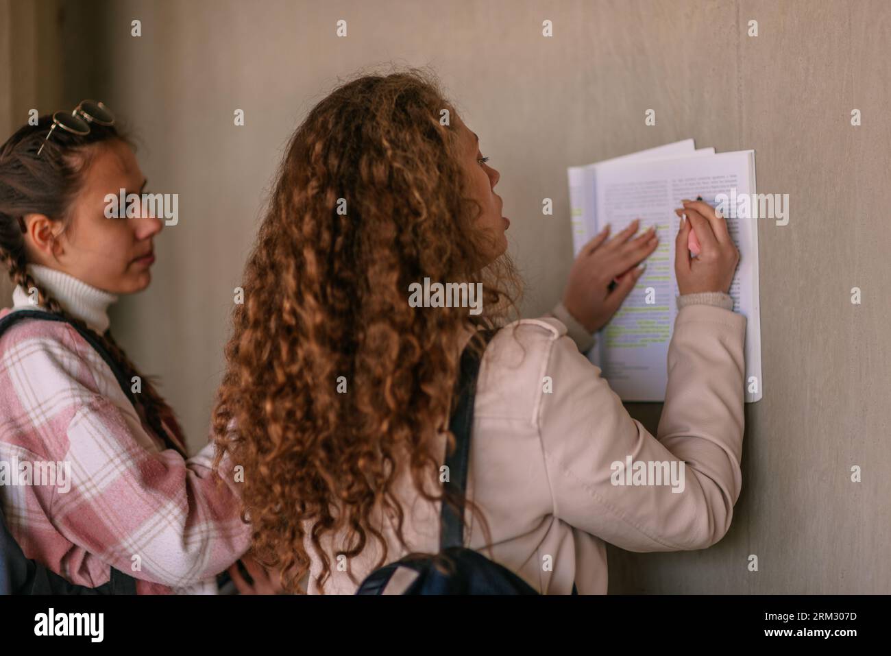 Beautiful school girls underlining important parts of the book. They ...