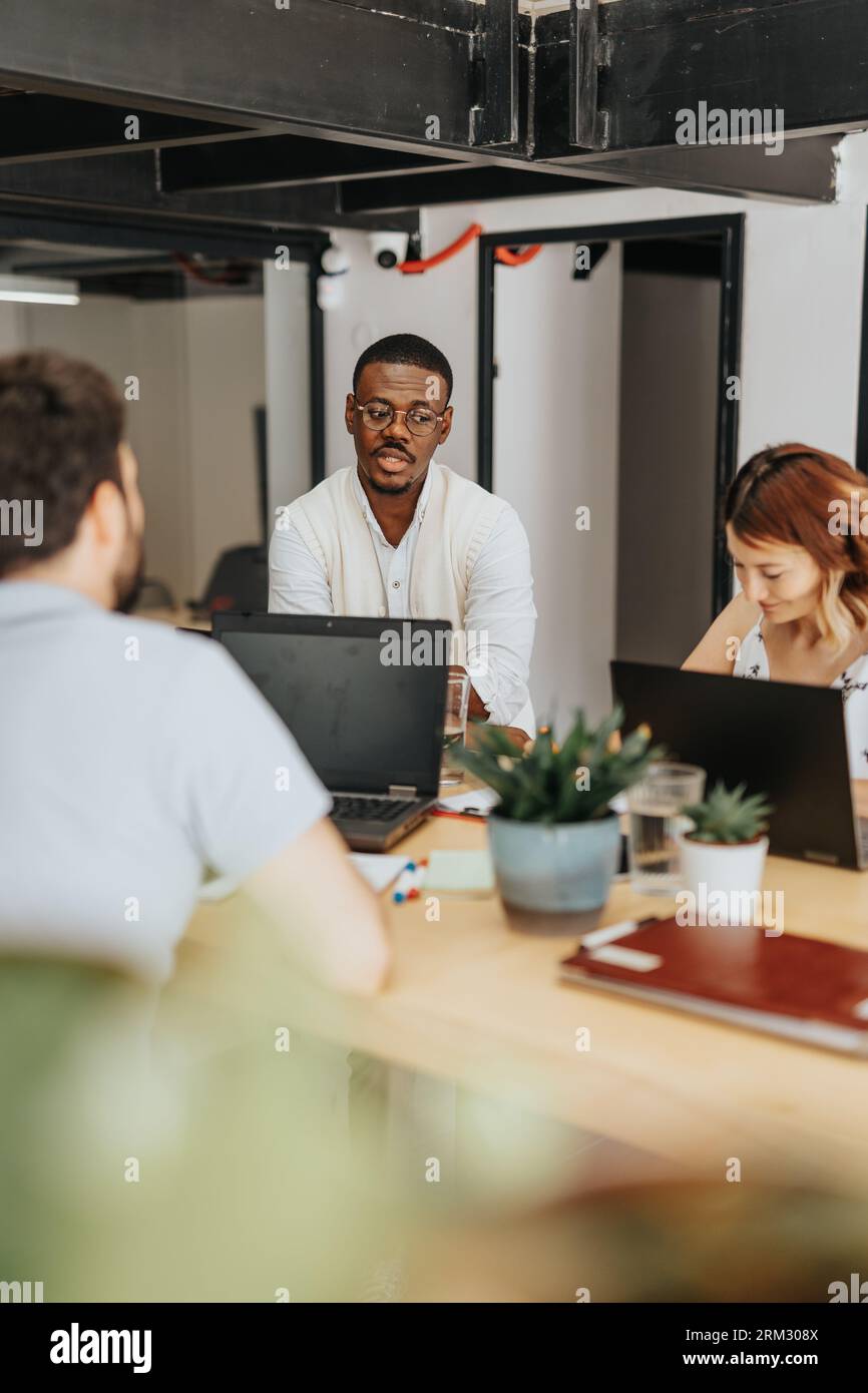 A successful multicultural business team works together in an office ...