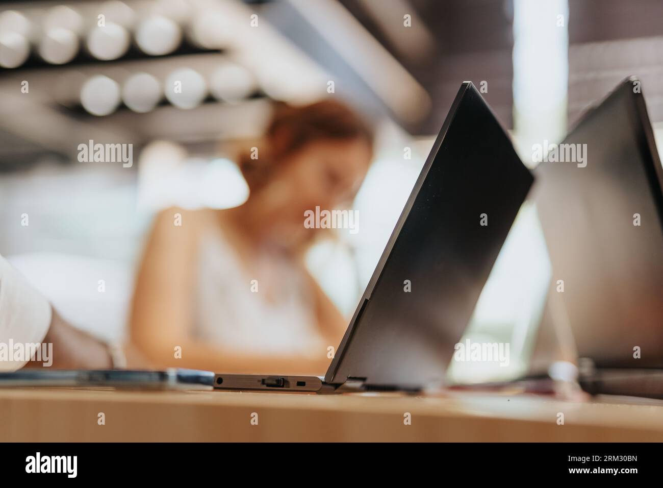 Blurred photo of young businesswoman working on lap top at the office ...